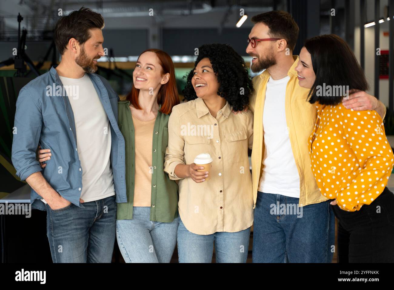 Five colleagues are laughing and chatting together during a break in ...