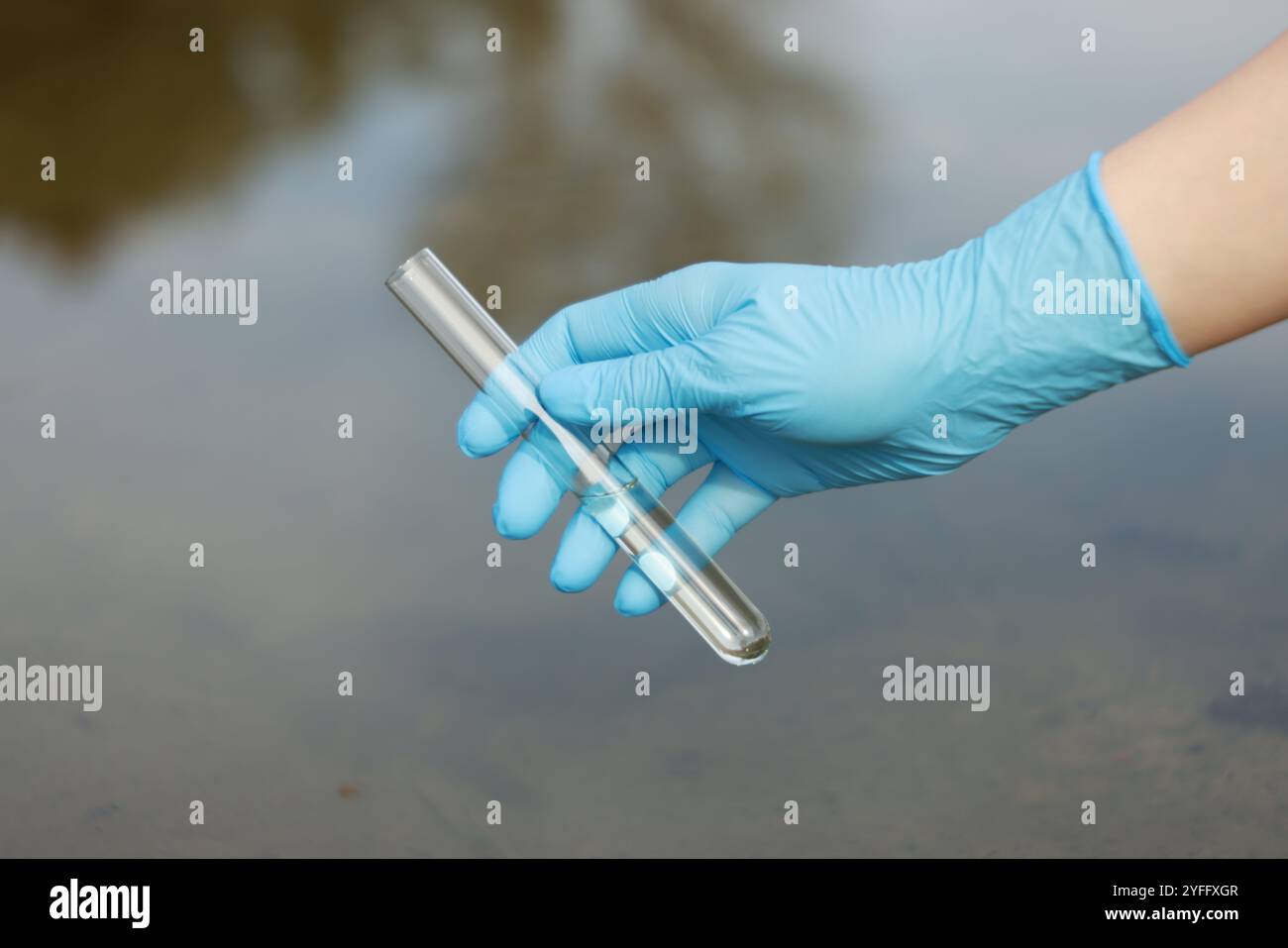 Examination of water quality. Researcher holding test tube with sample ...