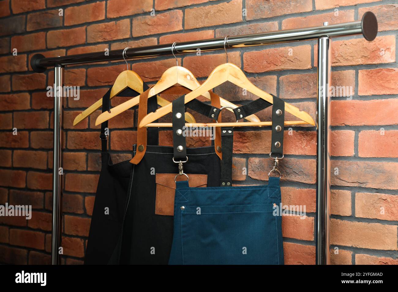 Many chef's aprons hanging on brick wall Stock Photo - Alamy