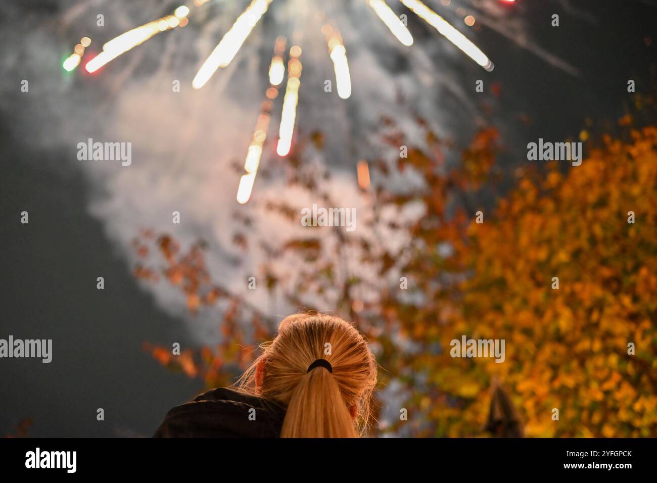 Families gather to watch a fireworks display in a pub beer garden to ...