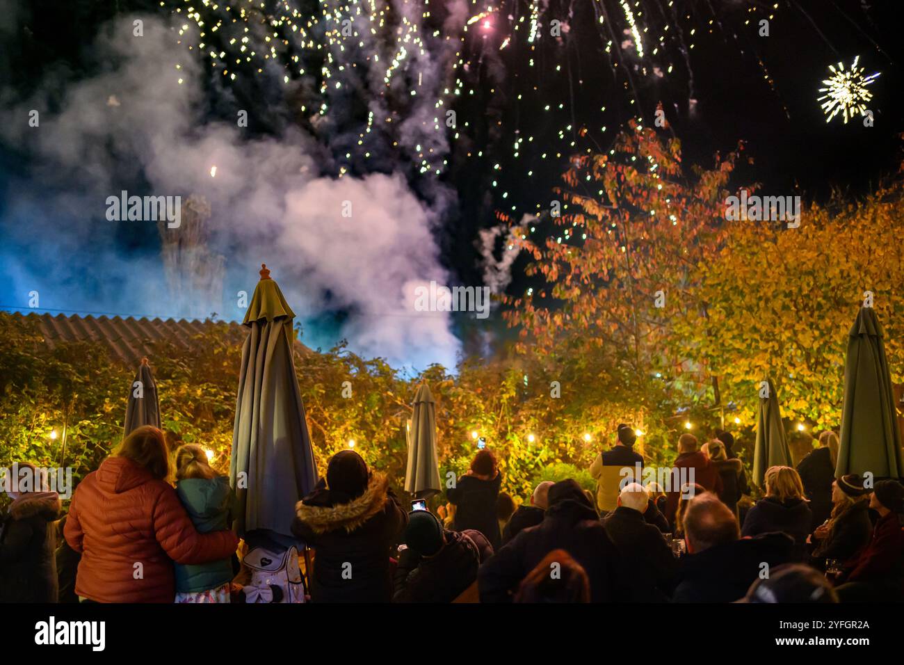 Families gather to watch a fireworks display in a pub beer garden to ...
