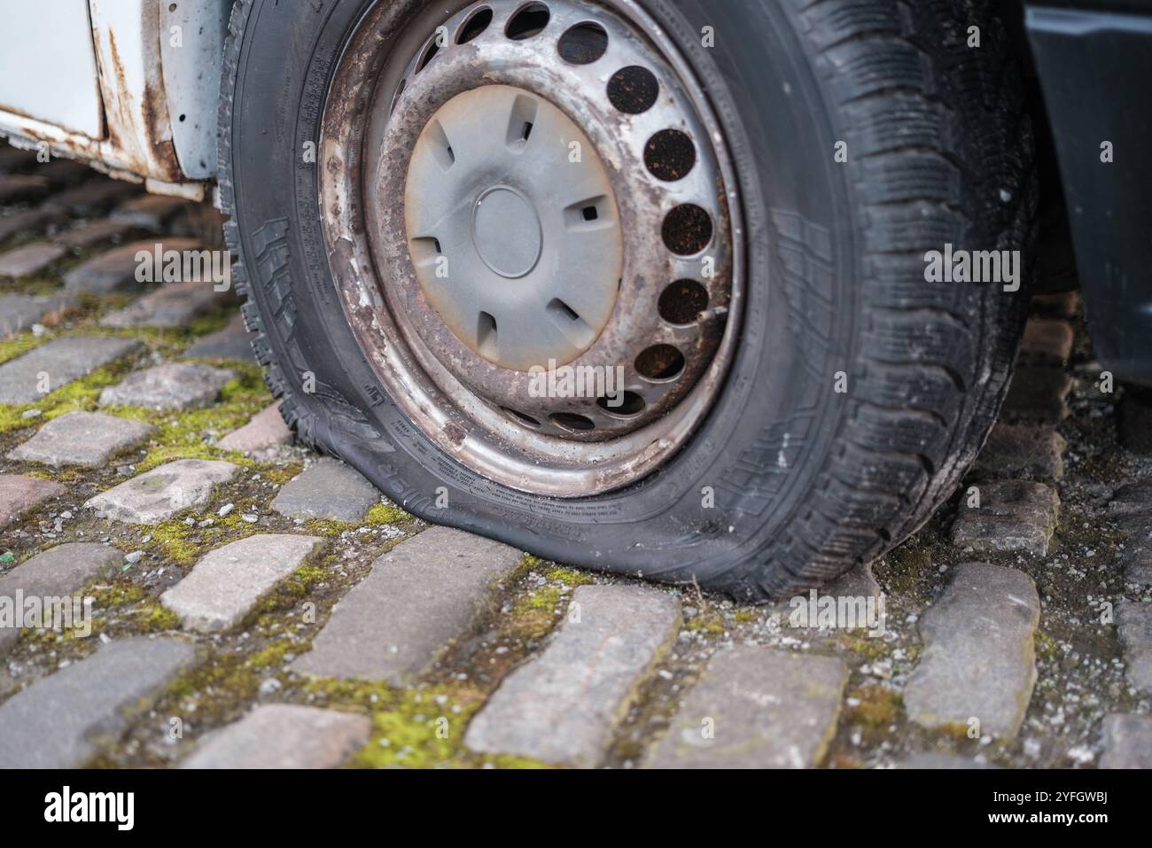 A Car With A Flat Tyre (Tire) On A Cobblestone Street Stock Photo - Alamy