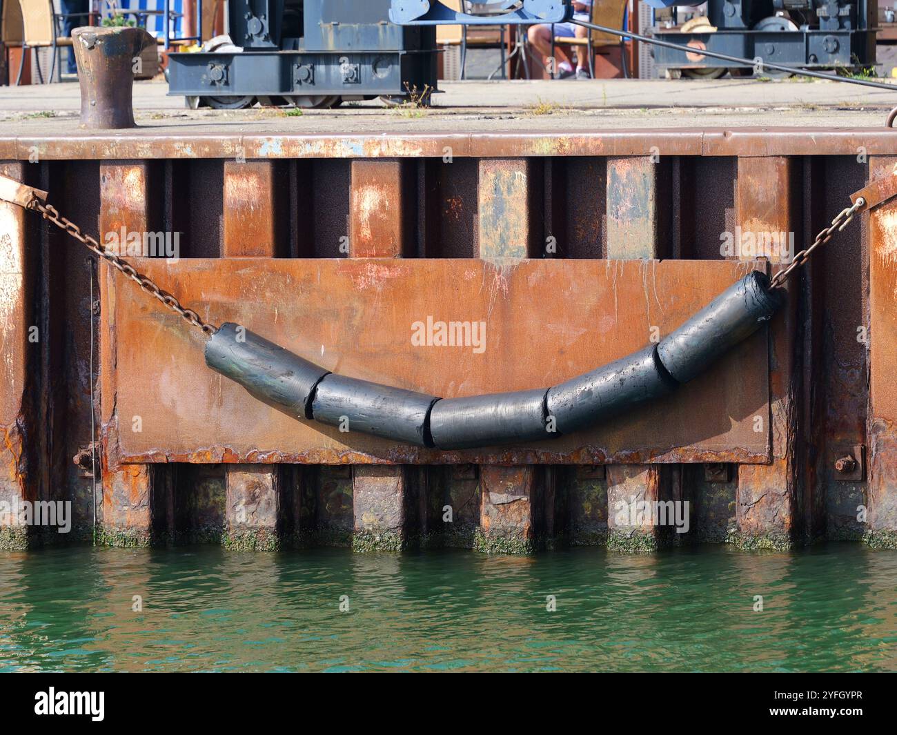 Dock fender - on the quay wall - The bright green of the water ...