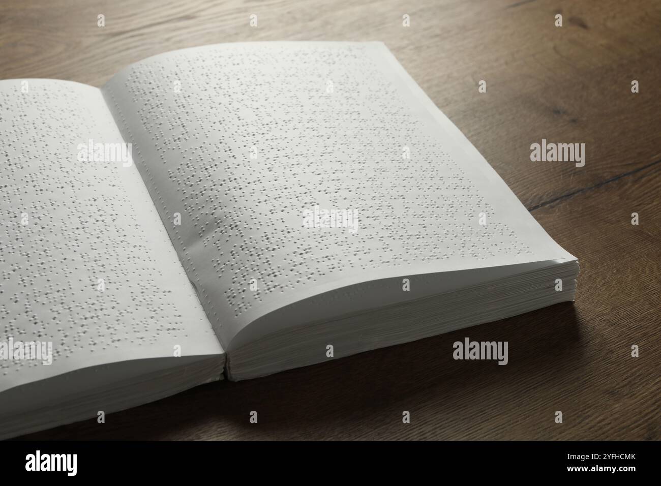 Book with Braille text on wooden table. Education and leisure for blind ...