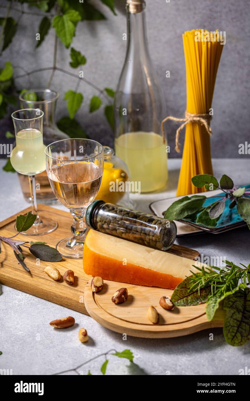 Italian culinary still life featuring cheese, pasta, wine, limoncello ...