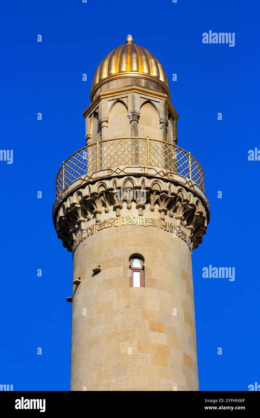 On ornate minaret with golden dome of the Taza Pir Mosque (1914) in ...