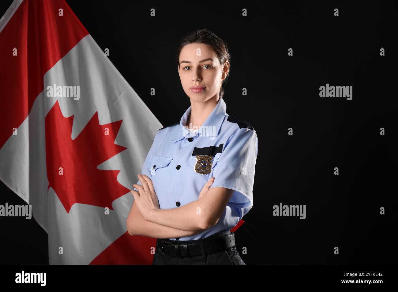 Female police officer and flag of Canada on dark background Stock Photo ...