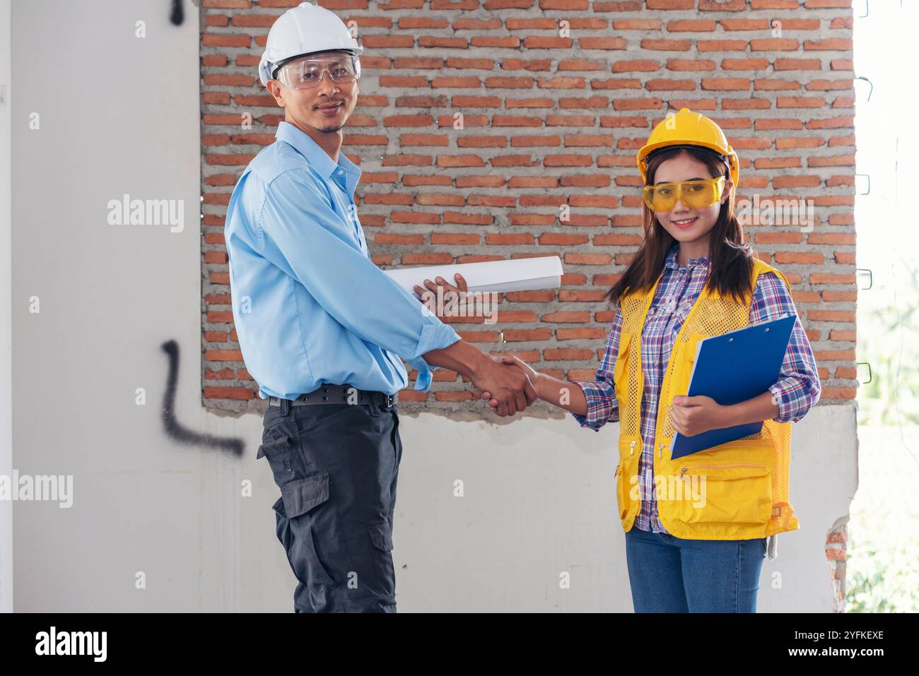 Civil Construction engineer teams shaking hands together wear work helmets worker on ...