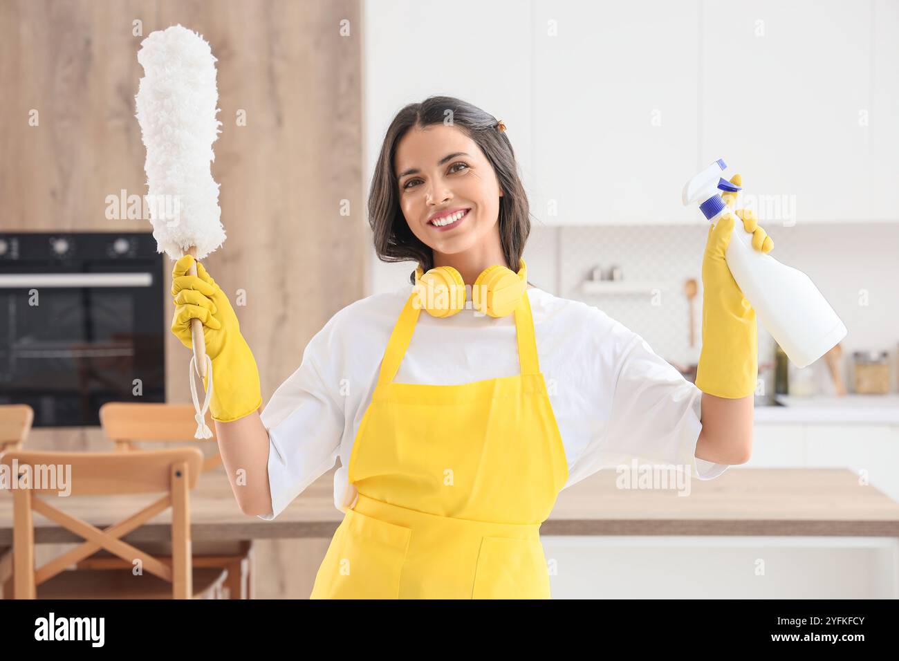 Female janitor with pp-duster and detergent in kitchen Stock Photo - Alamy