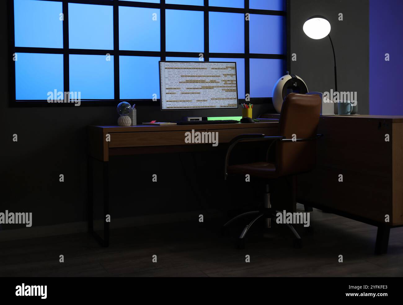Interior of dark programmer's office with workplace and glowing lamp ...