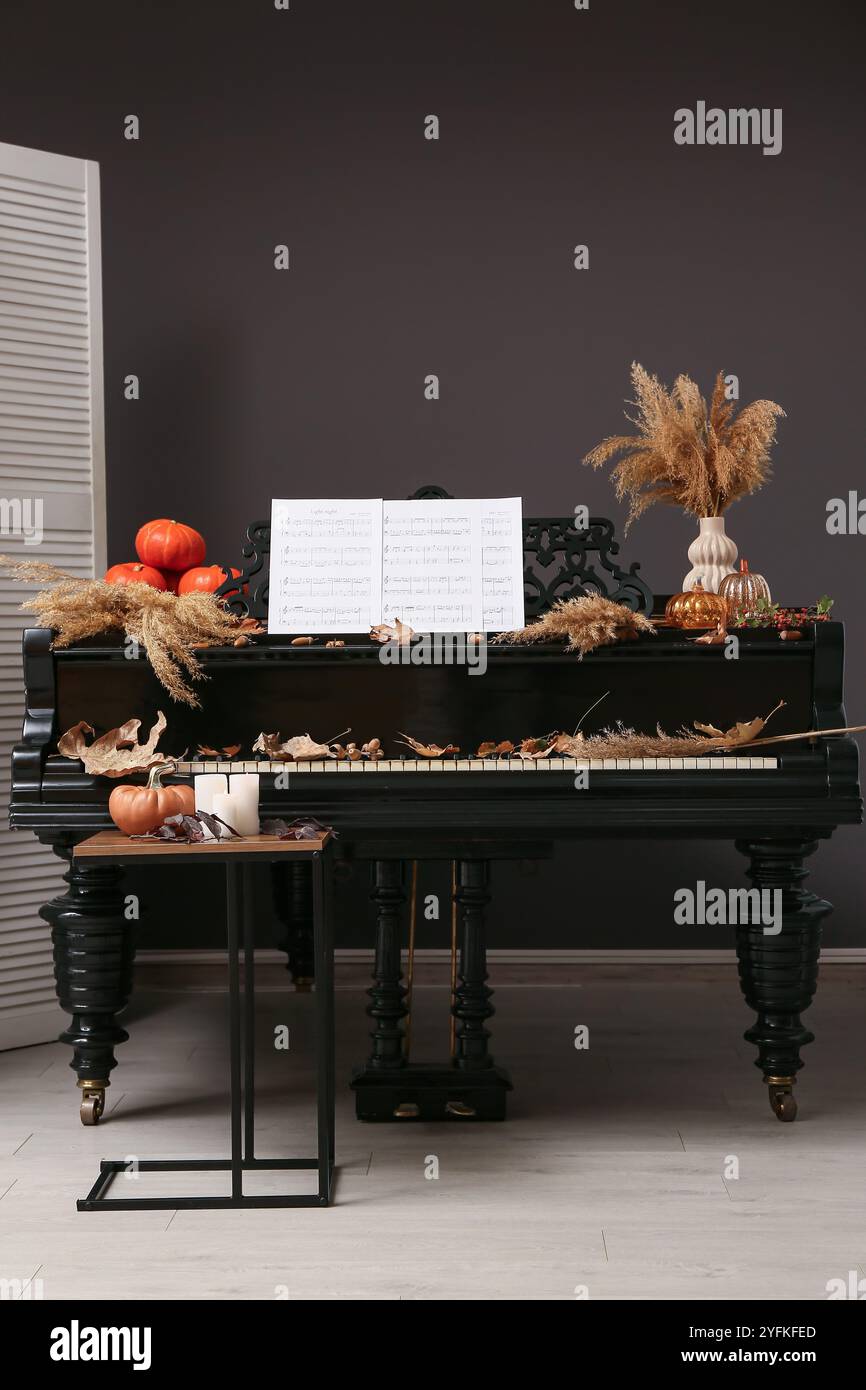Piano with musical notes and autumn decoration in room Stock Photo - Alamy