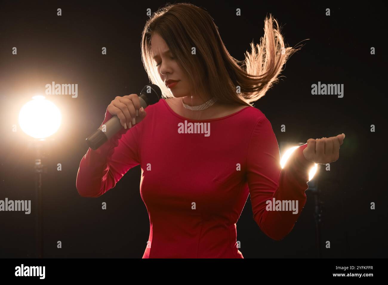 Beautiful female singer with microphone on dark background Stock Photo ...