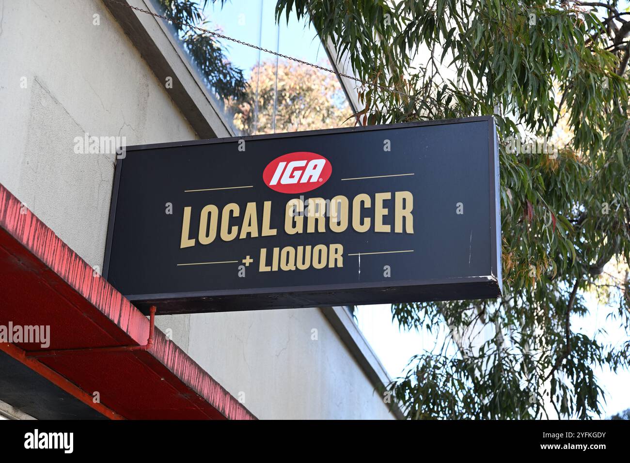 Black rectangular IGA Local Grocer + Liquor sign above the entry of a ...