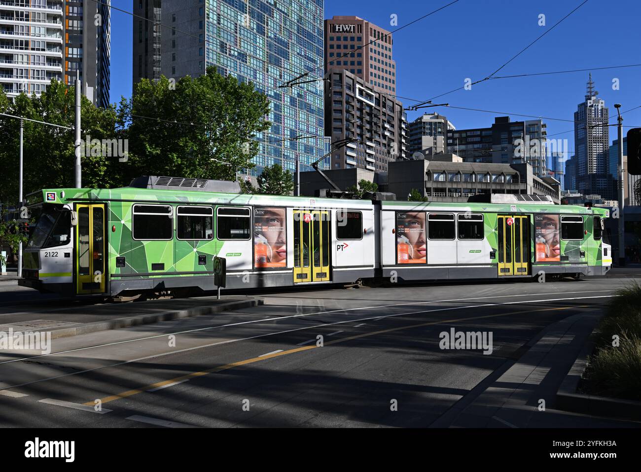 Side view of a B-class tram as it turns at an intersection, with ...