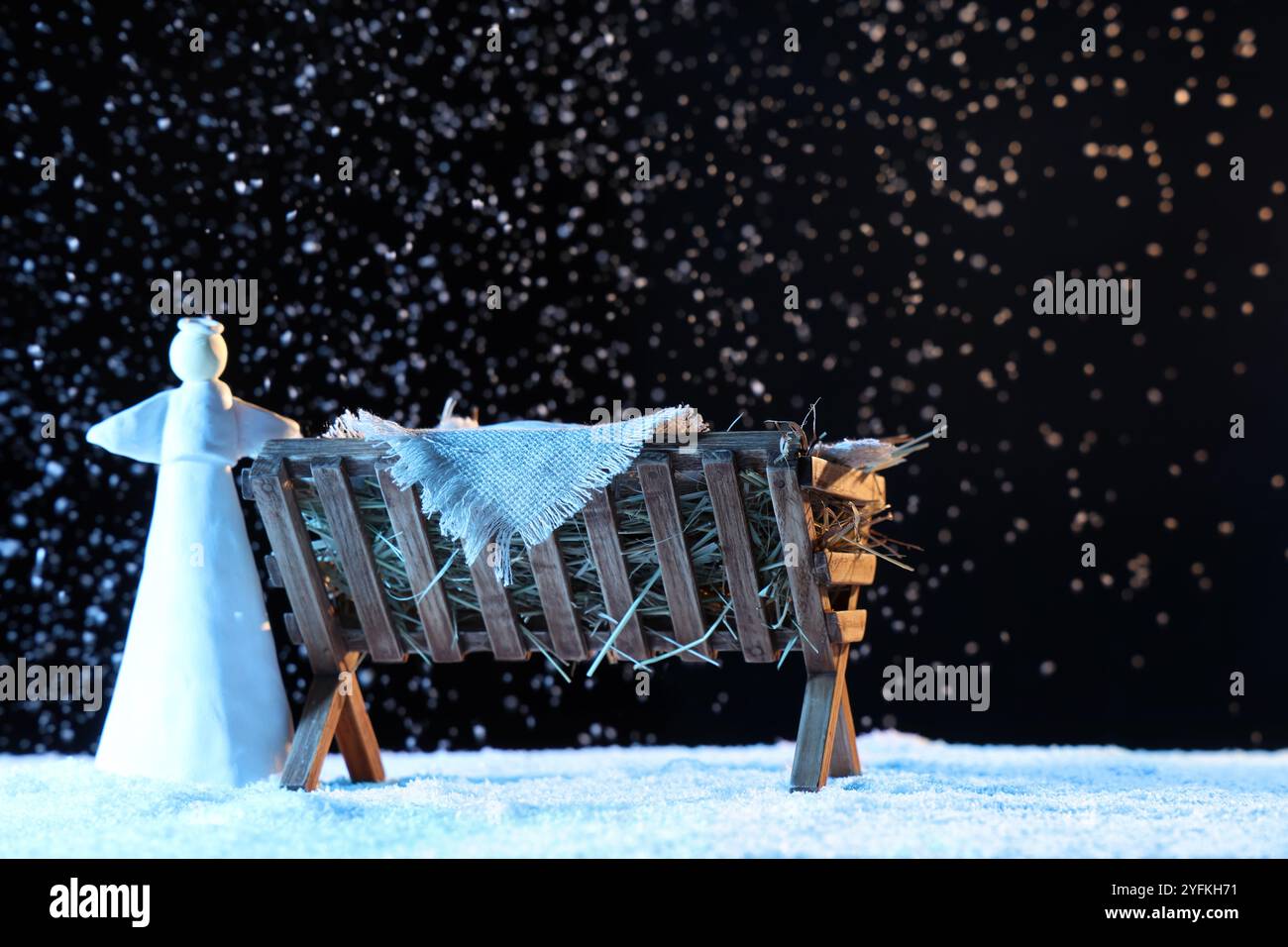 Manger with baby Jesus and angel on snow against dark background Stock ...