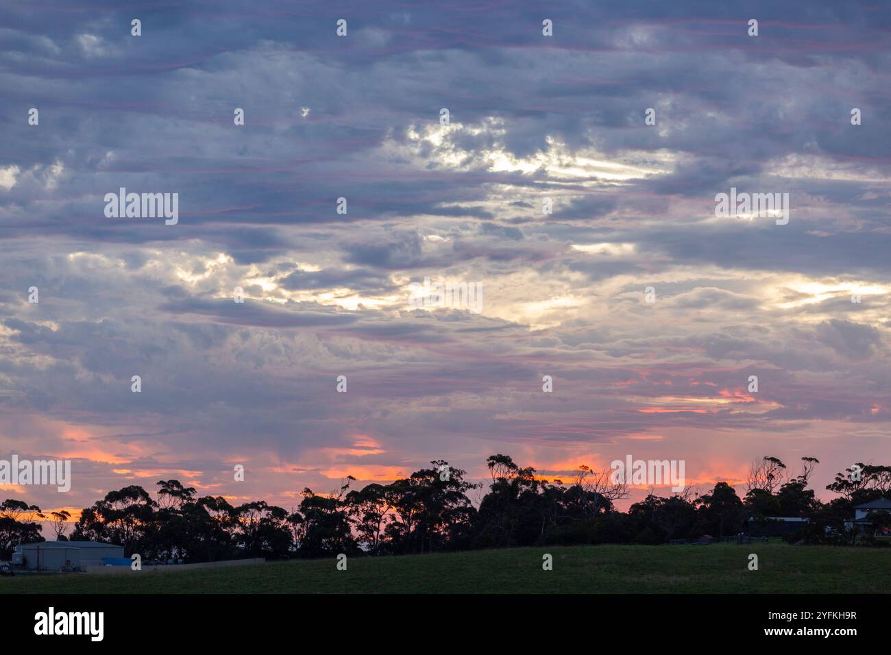 Dramatic, sunset skies with layers of cloud swirling and blue and pink ...