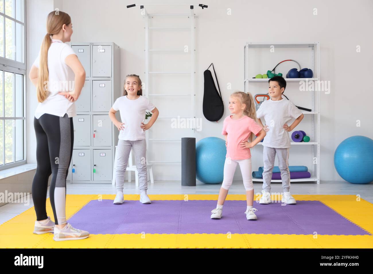 Cute little children training with coach in gym Stock Photo - Alamy