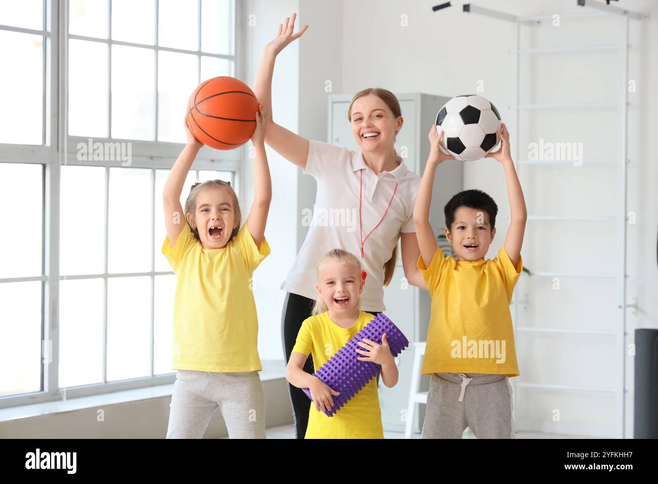 Cute little children with sports equipment and trainer in gym Stock ...