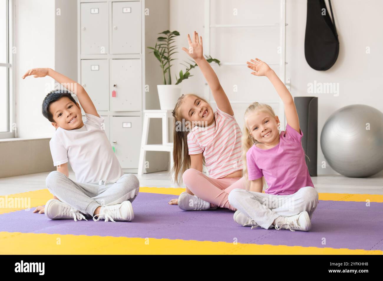 Cute little children stretching in gym Stock Photo - Alamy