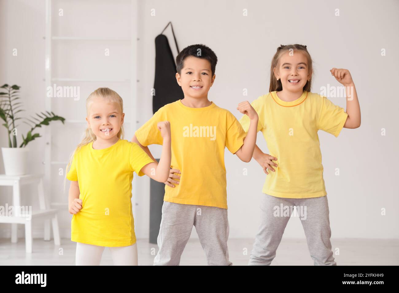 Cute little children showing muscles in gym Stock Photo - Alamy
