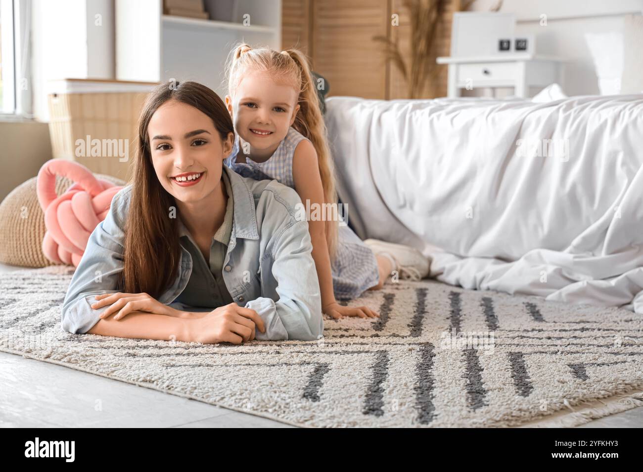 Nanny with cute little girl lying on carpet in bedroom Stock Photo - Alamy