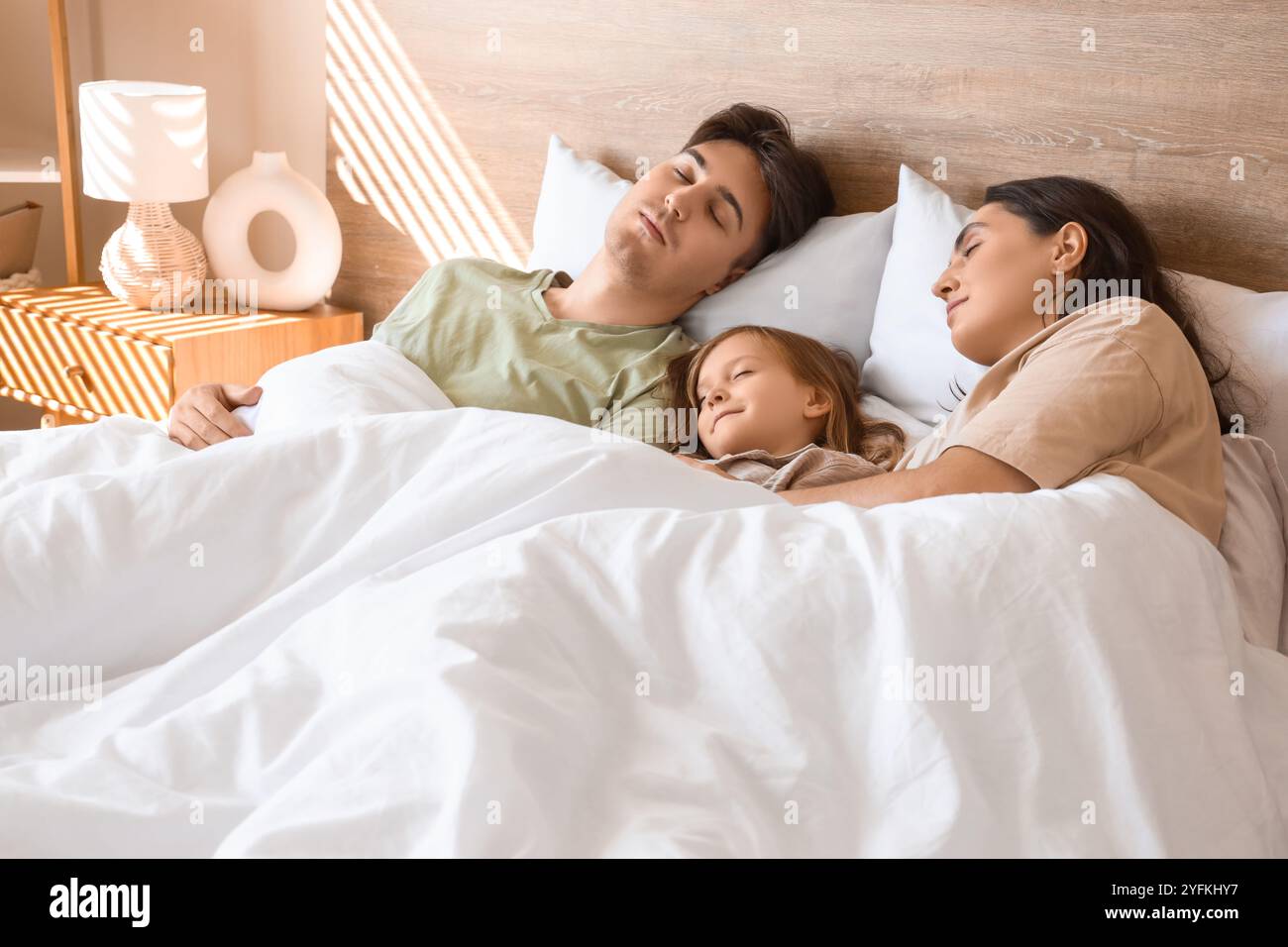 Little girl with her parents sleeping in bedroom Stock Photo - Alamy