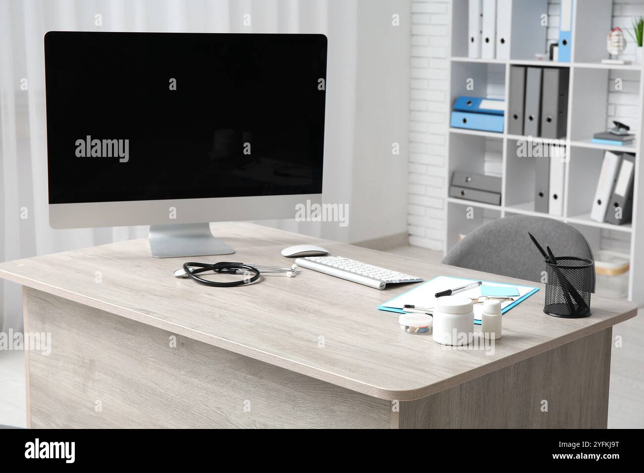 Doctor's workplace with blank computer monitor and medical supplies in ...