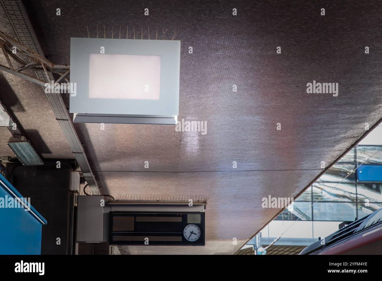 An empty white information board is mounted in a train station ...