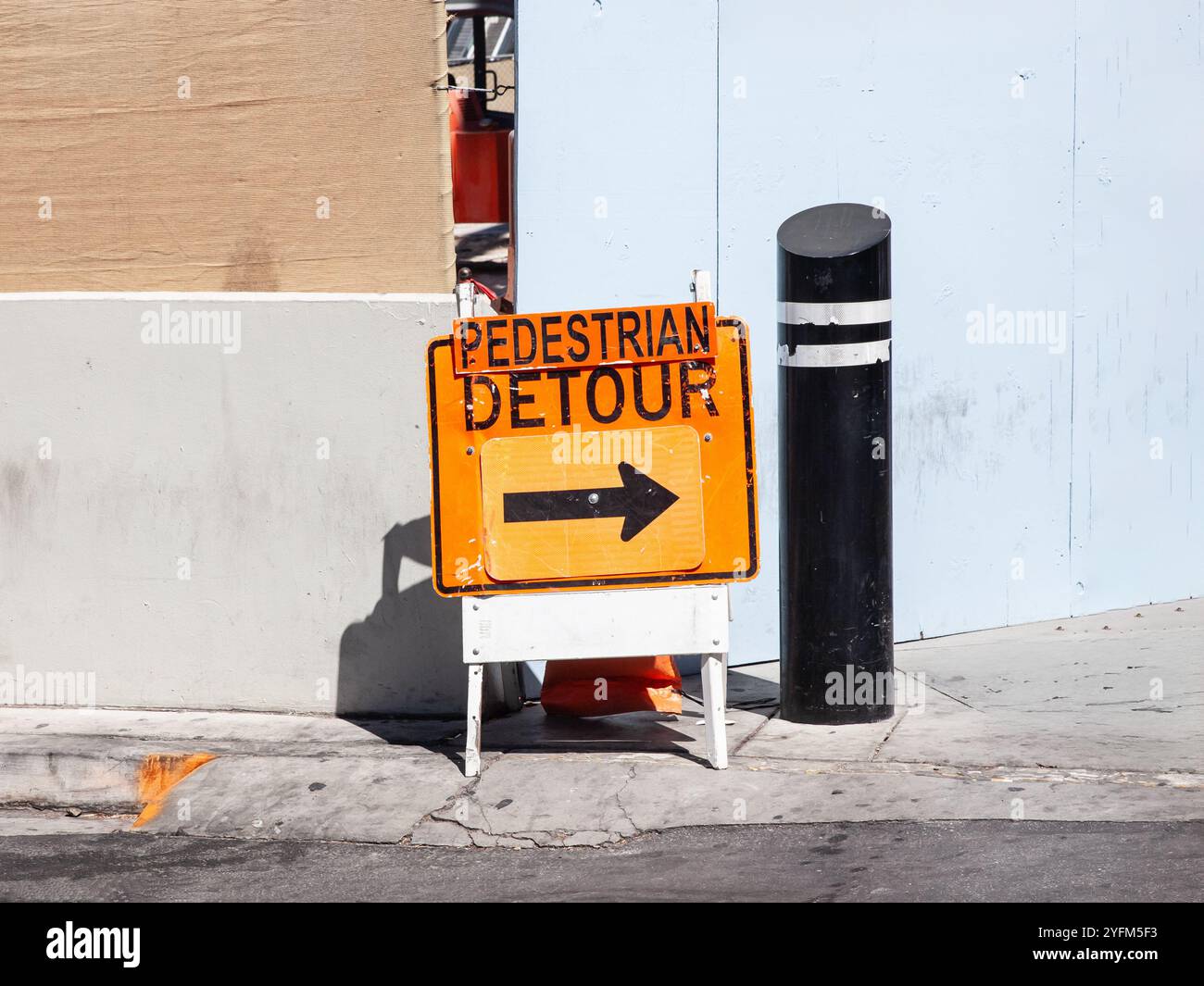 A pedestrian detour sign compliant with the MUTCD stands by a ...