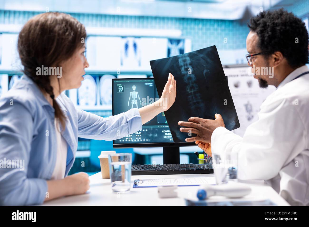 General practitioner examining x ray scan test results with patient ...