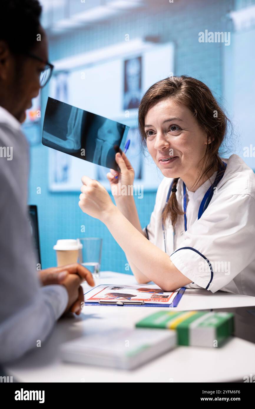 Physician presenting x ray imaging for the right diagnostic during check up, explaining the lab ...