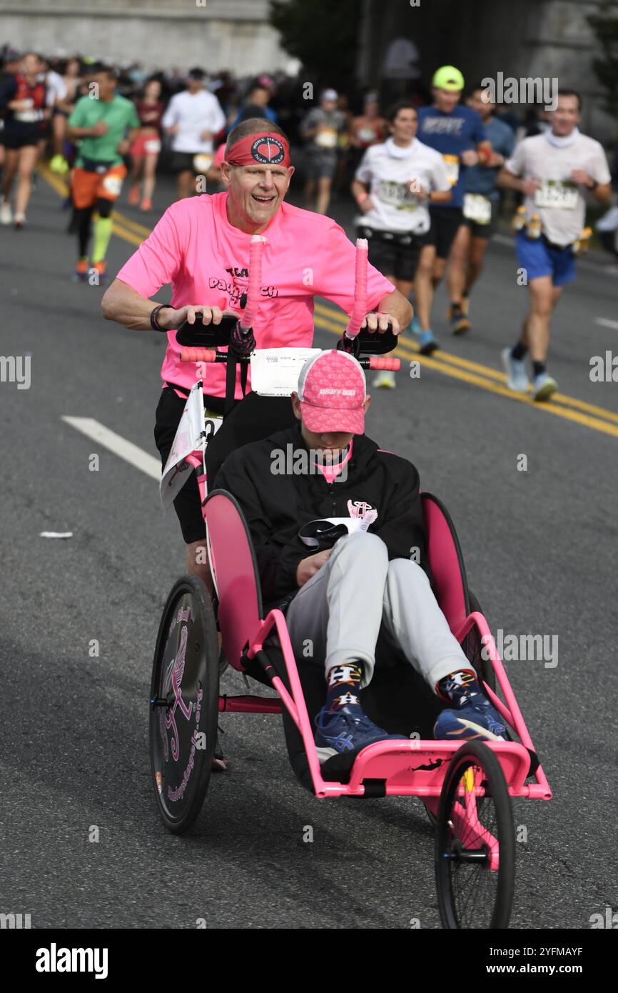 Male running pushing disabled person in a Wheelchair bike pink color ...