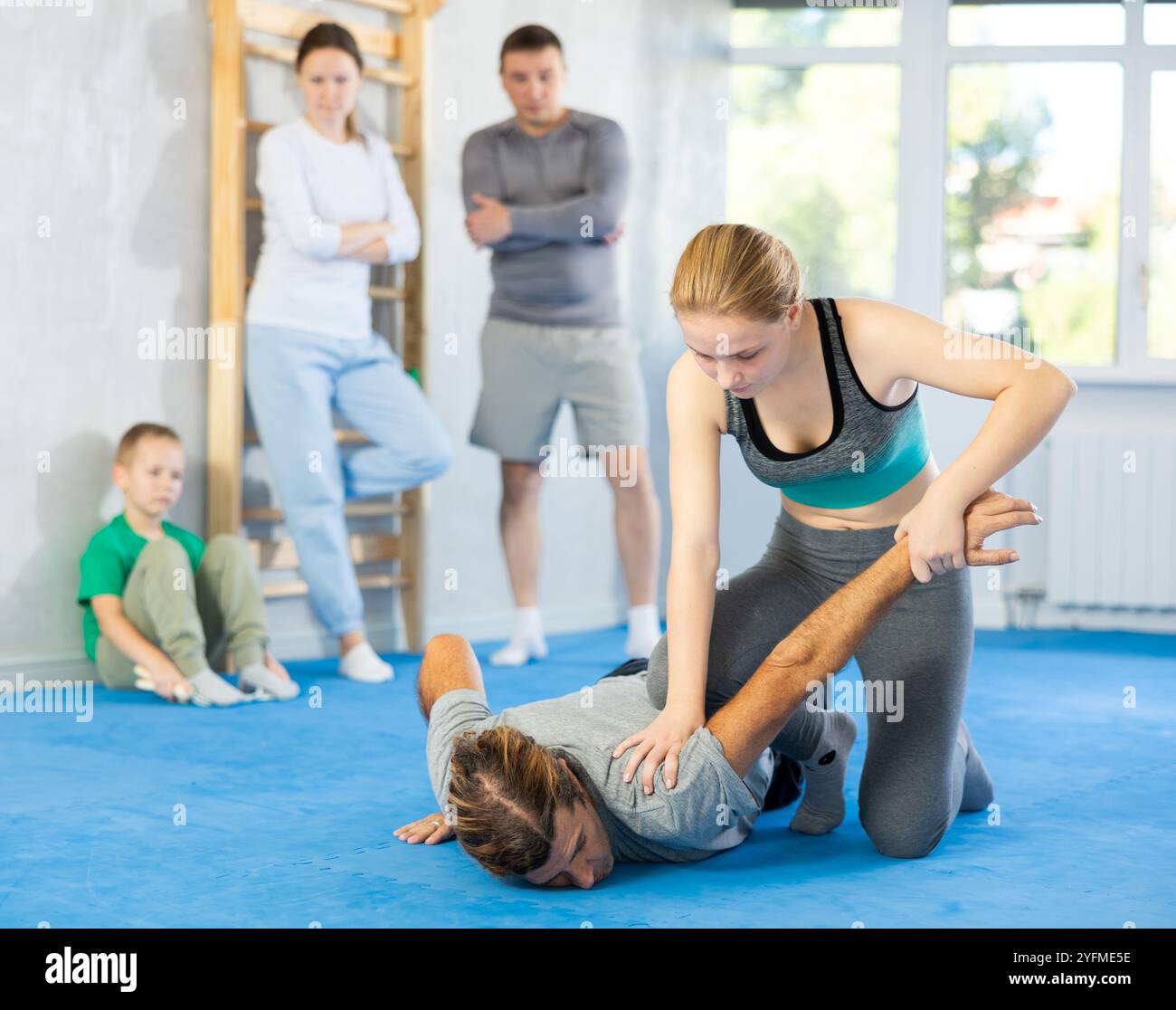 Teen girl in gym perform basic elements of krav maga self-defense ...
