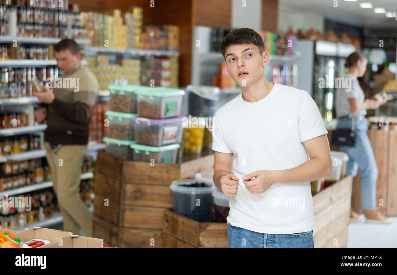 Guy walks through supermarket and chooses what purchases to make Stock Photo - Alamy