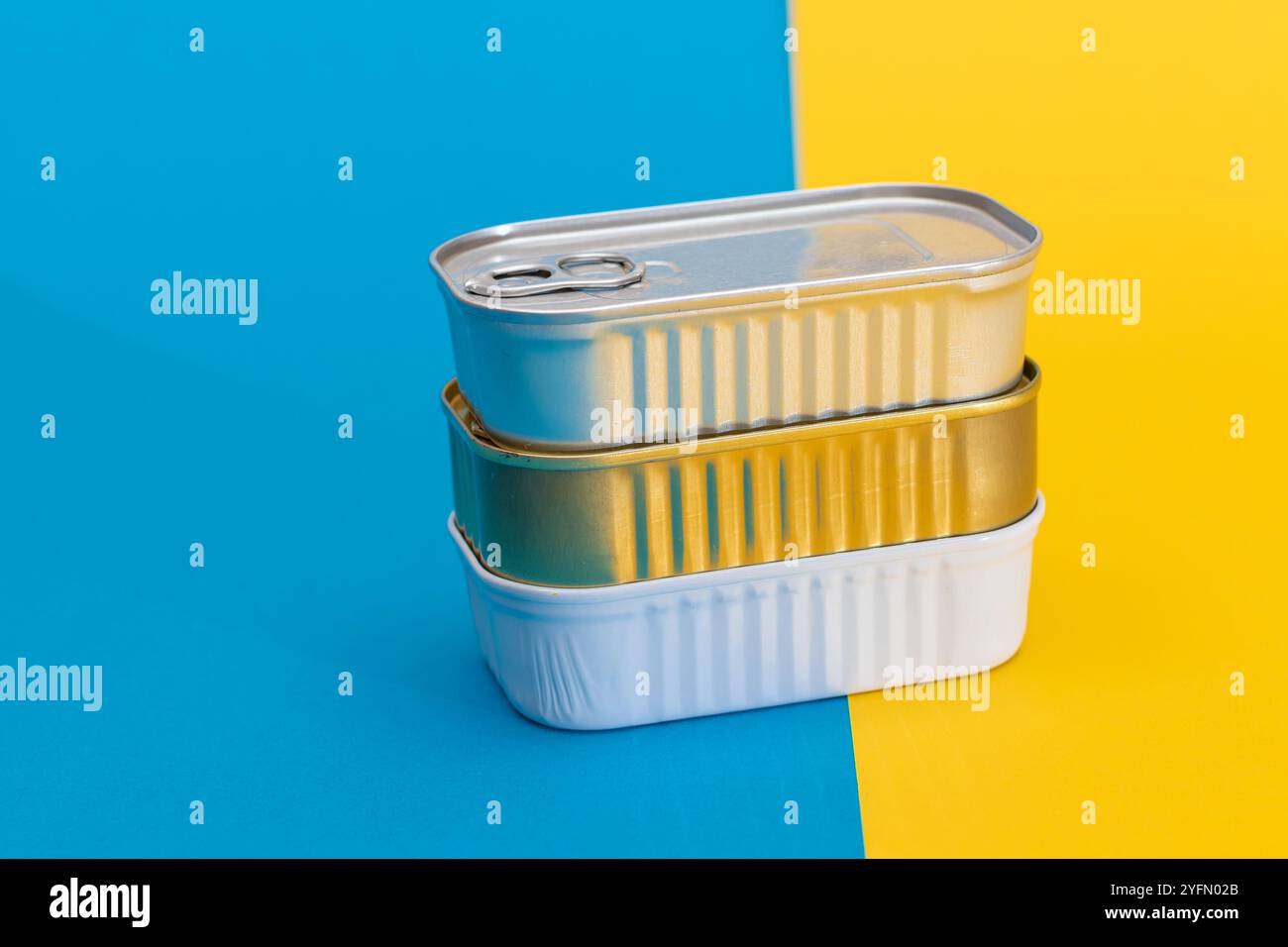 A Group of Stacked Tin Cans on Split Blue and Yellow Background. Canned ...