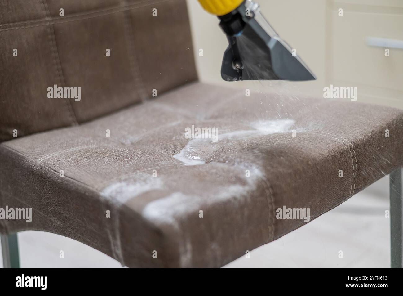 Dry cleaning a fabric chair Stock Photo - Alamy
