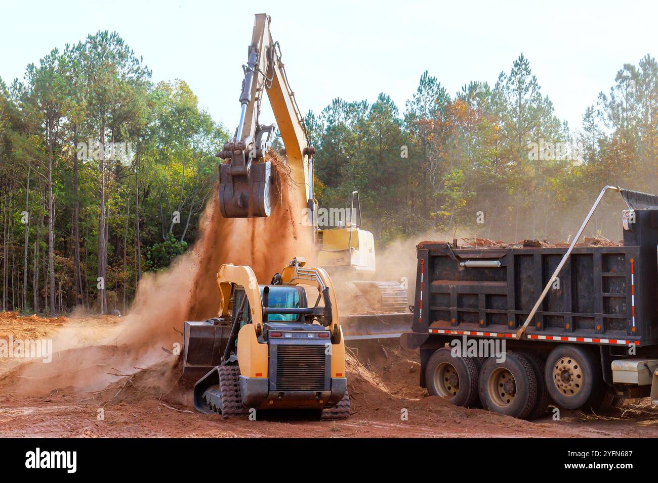 Loading land into dump truck using excavator at construction site Stock Photo - Alamy