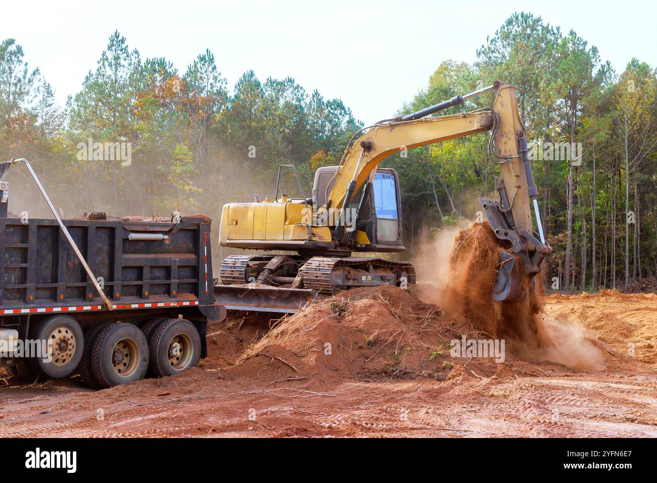 Process of loading earth into dump truck using an excavator at construction site Stock Photo - Alamy