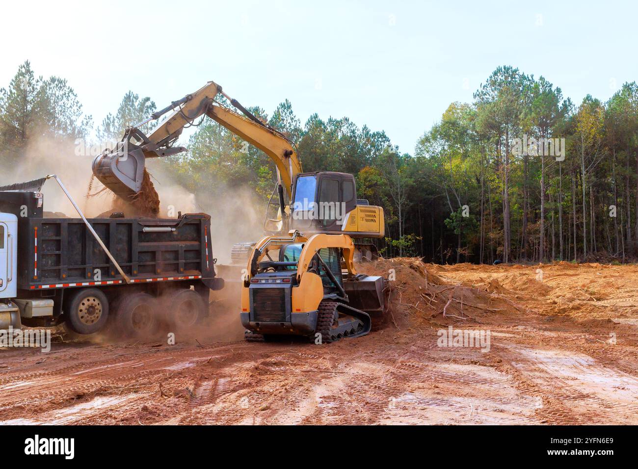 An excavator is used to load earth into dump truck on construction site ...