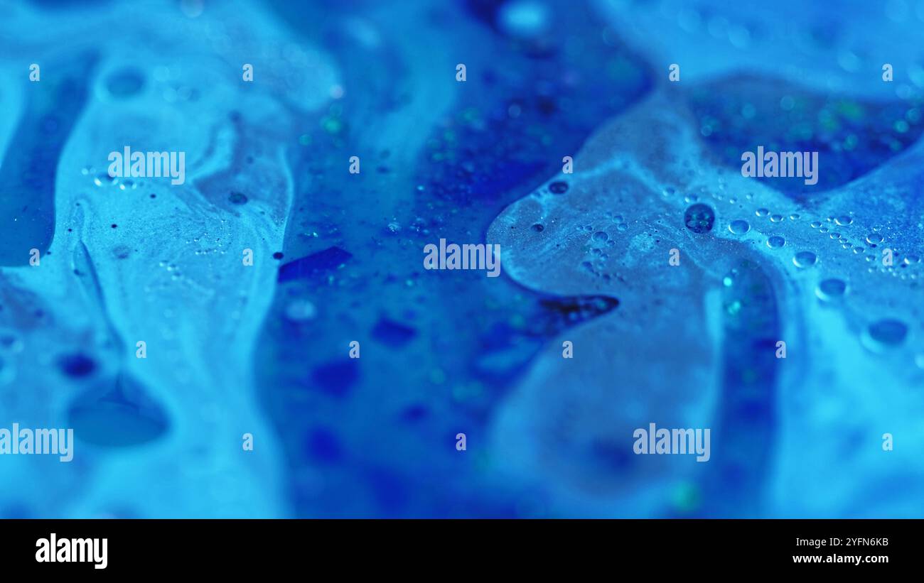Sparkling fluid. Glitter oil drip. Defocused blue color shiny grain ...