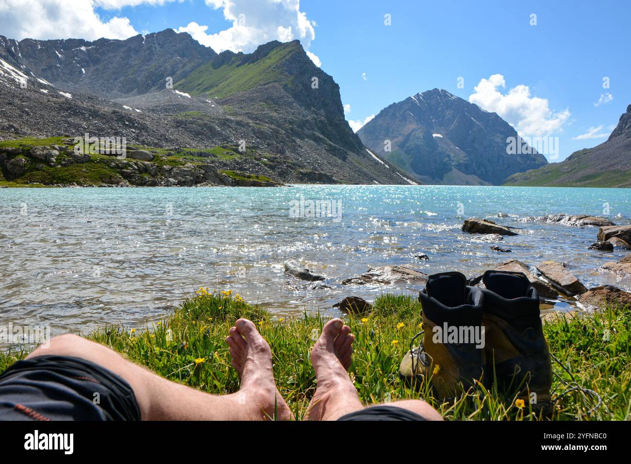 Personal perspective of one hiker's legs lying on the green grass and ...