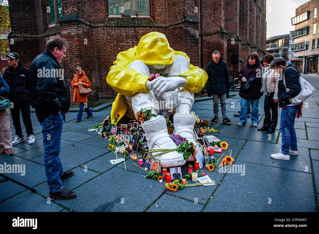 A view of the statue decorated with photos and candles. "Silent ...