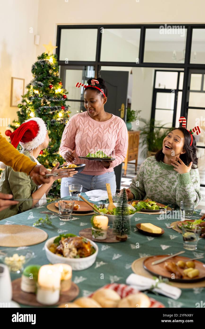 Multiracial friends sharing laughter and holiday cheer, christmas ...