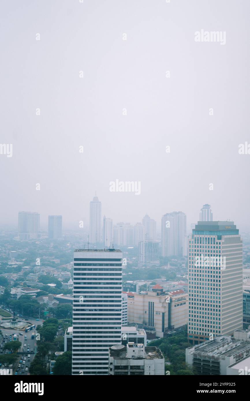 High-rise buildings and a major road in Jakarta city, with visible air ...