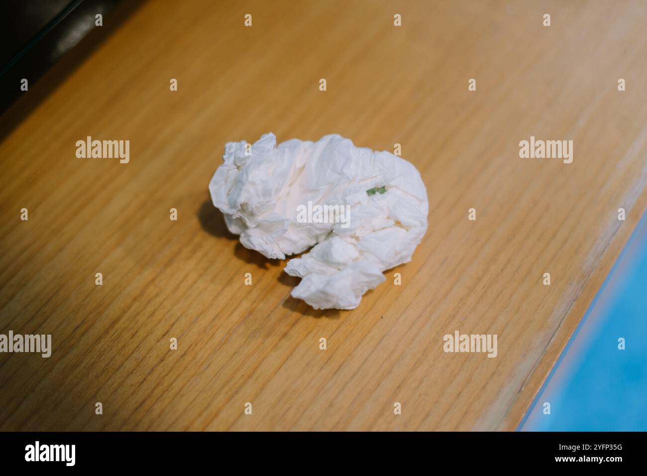 Used tissue paper discarded, crumpled and resting on a plain surface ...