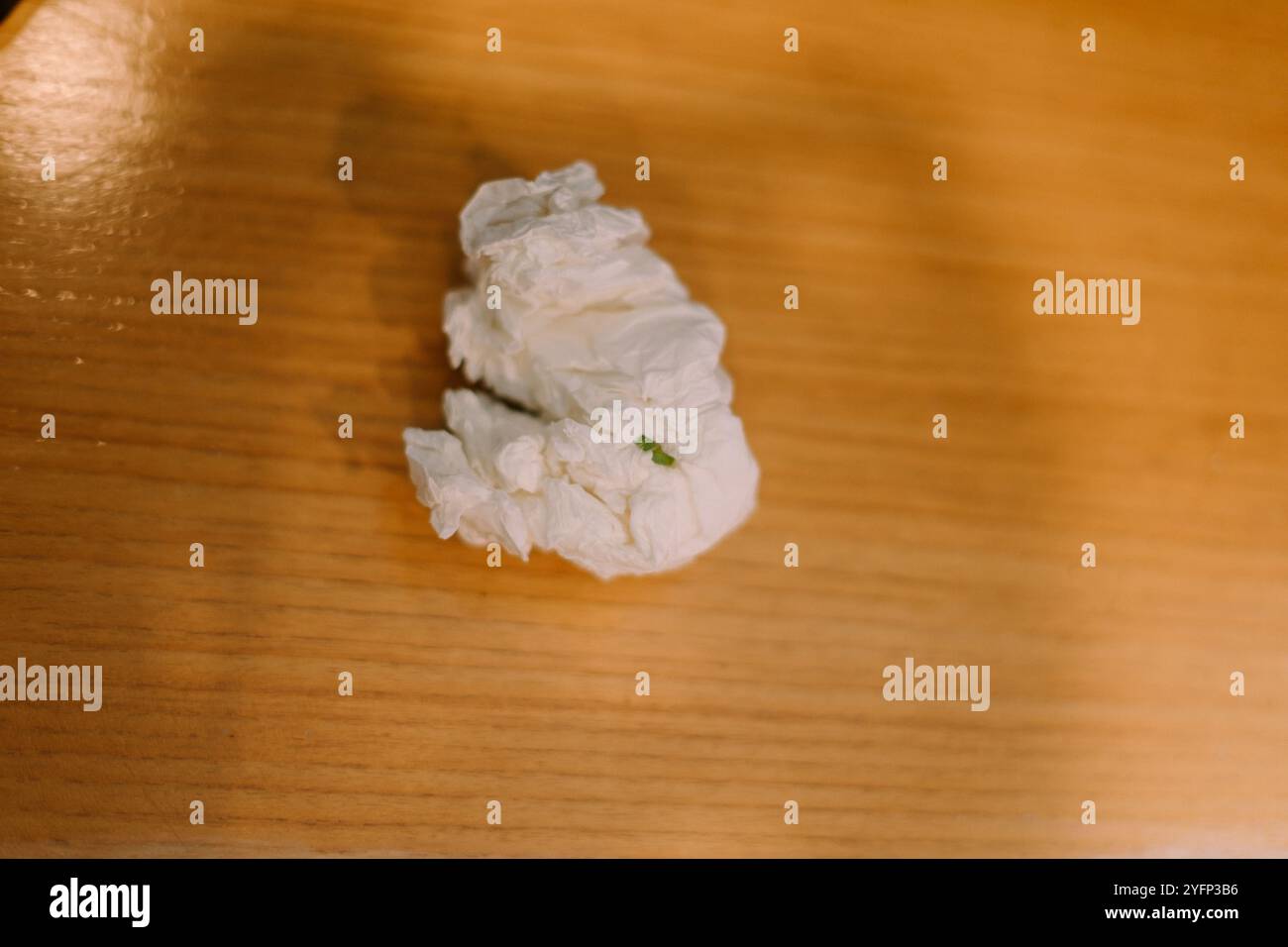 Used tissue paper discarded, crumpled and resting on a plain surface ...