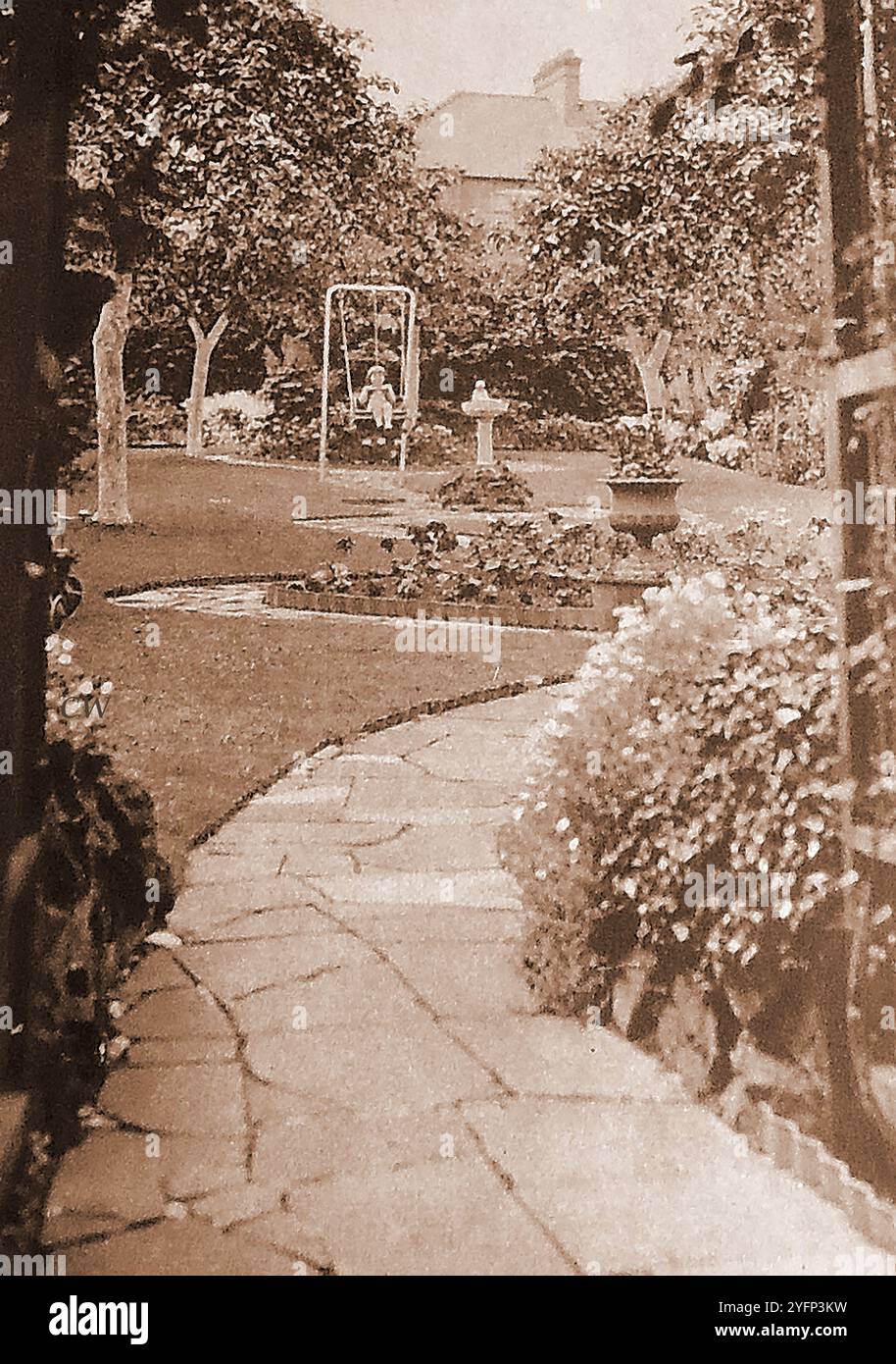A typical 1940's upper class British garden with a child's swing Stock ...