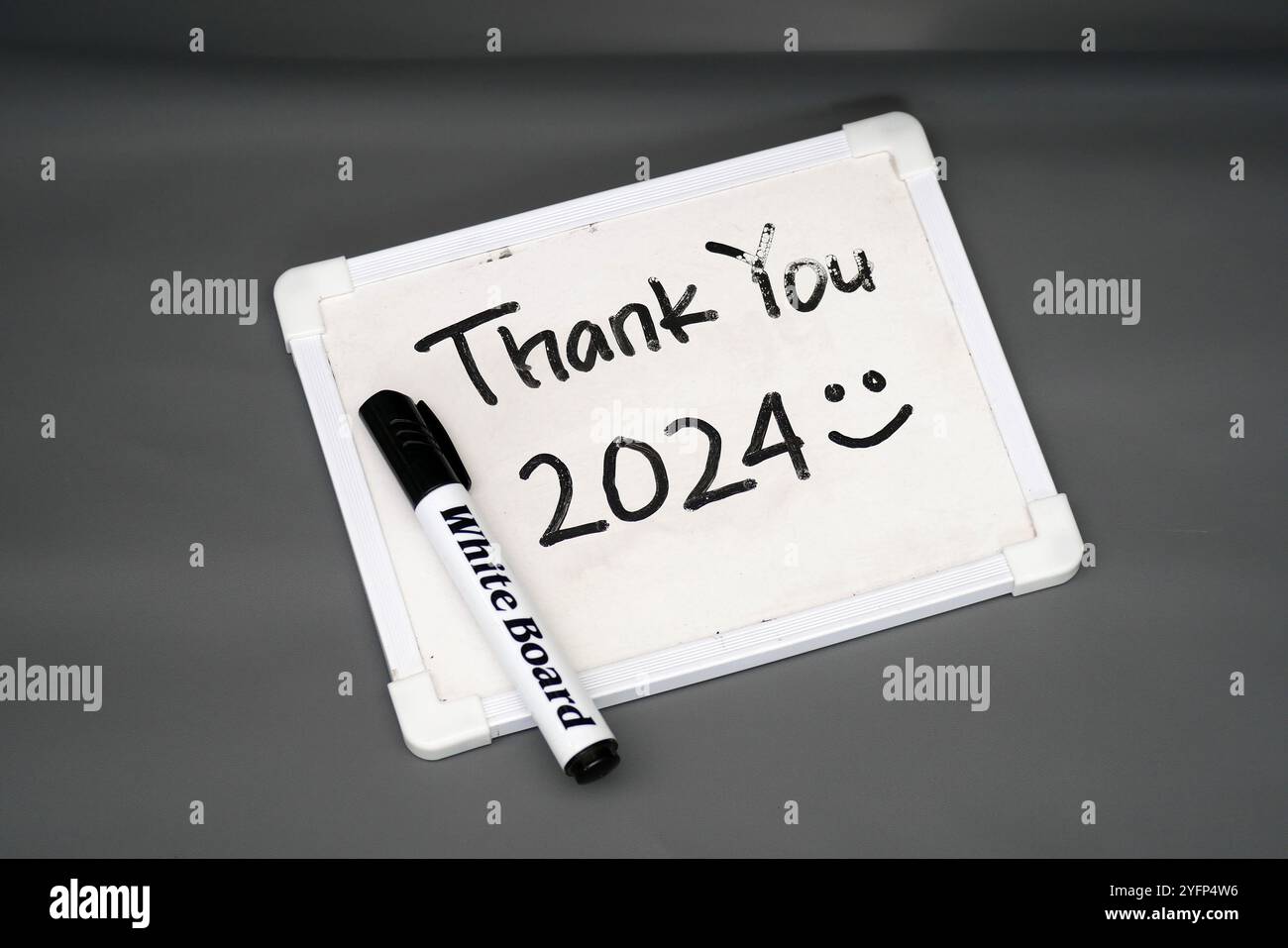 A small whiteboard with the words "Thank You 2024" and a black marker ...