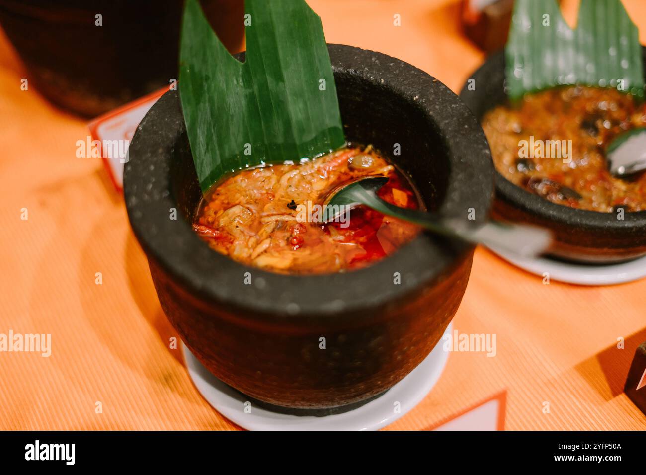 An assortment of traditional sambal varieties in clay bowls, showcasing ...