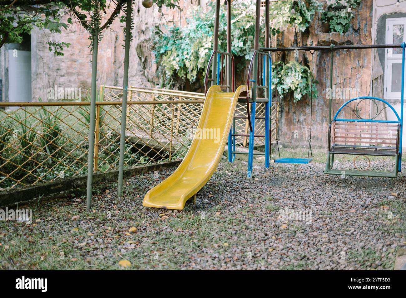 Playground slide and swings in a luxury residential complex, offering a safe and stylish play ...